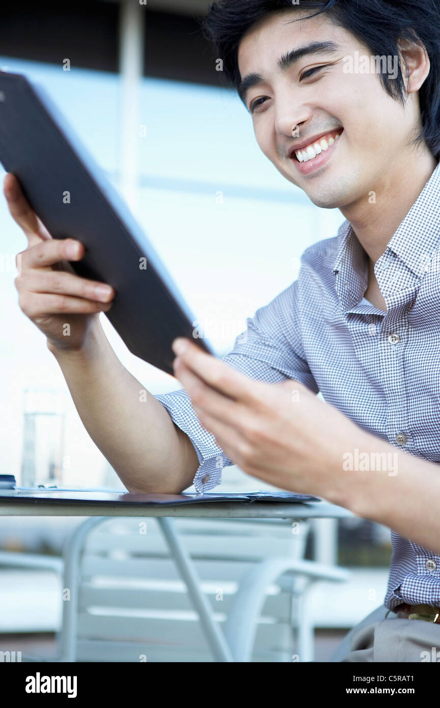 A man looking at a notepad Stock Photo - Alamy