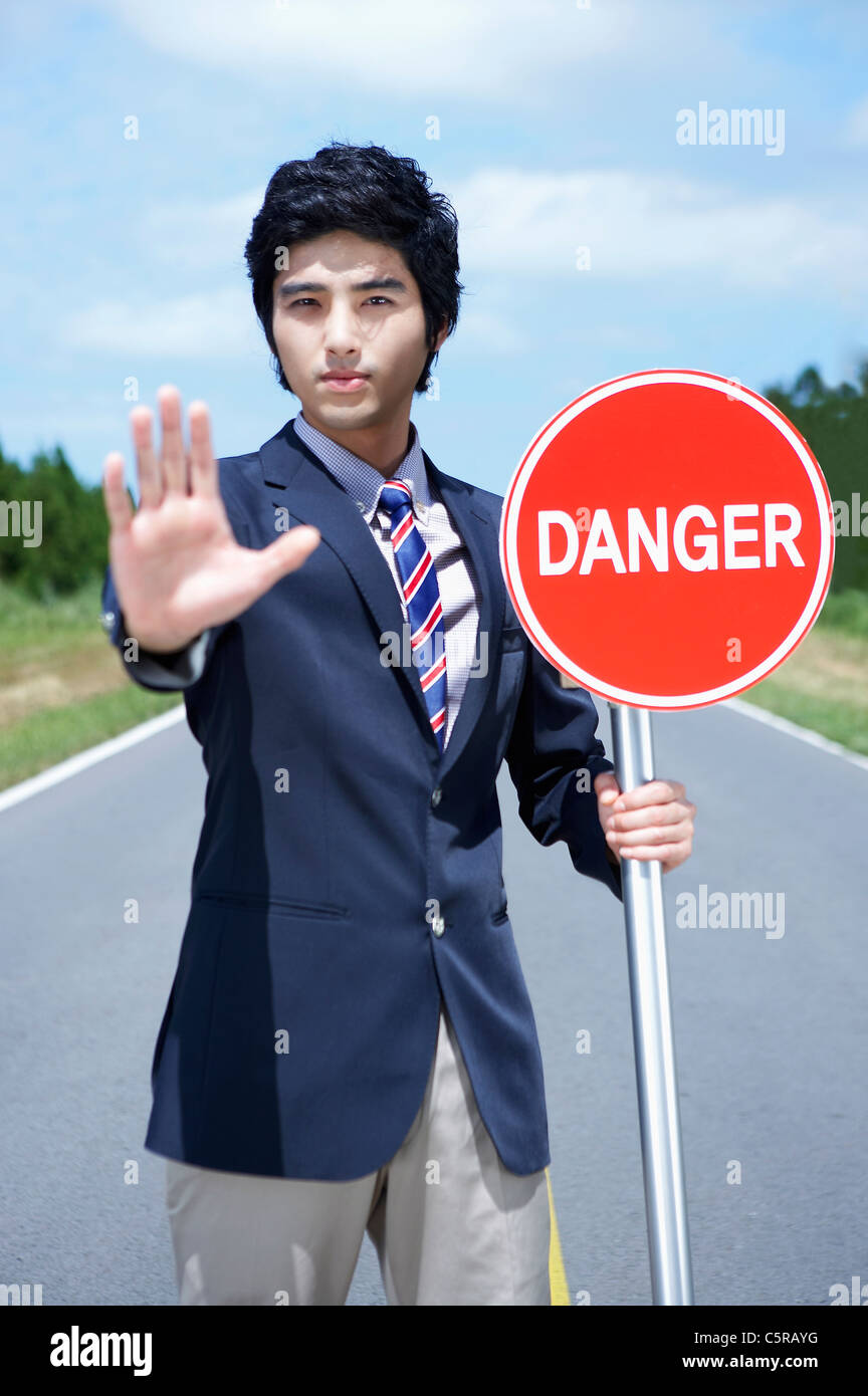A man holding a danger sign Stock Photo - Alamy