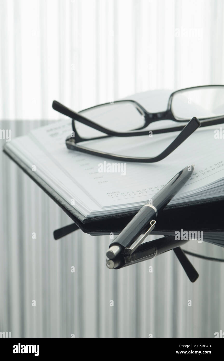 Close up of notebook, pen and spectacles with reflection on table Stock ...