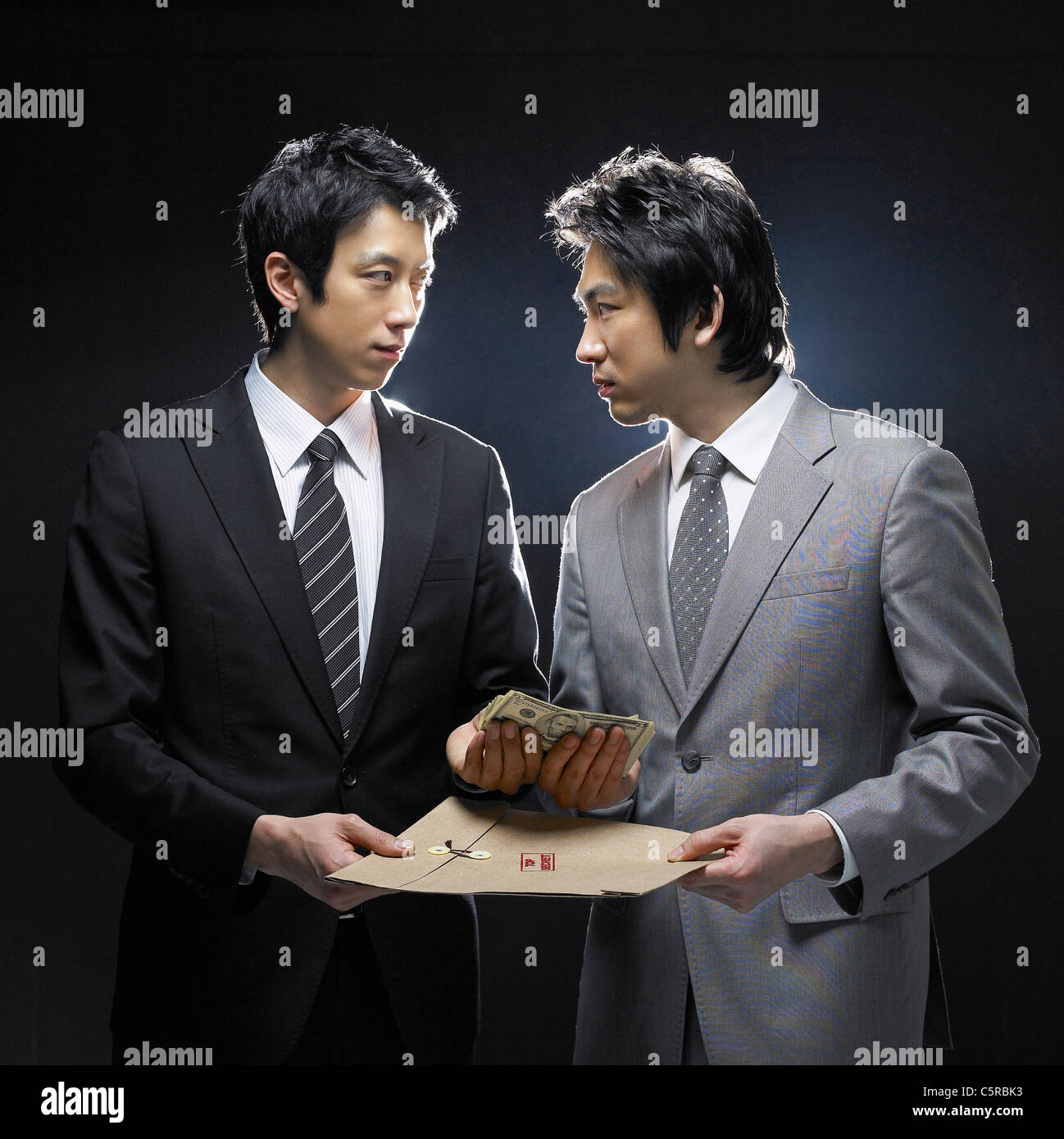 Two men exchanging money and information Stock Photo - Alamy