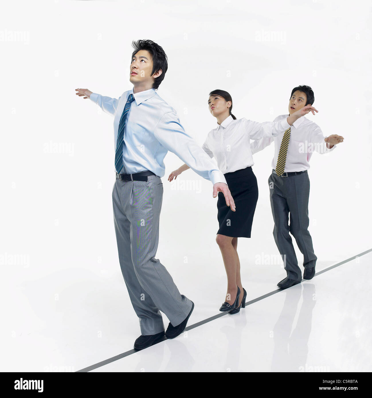 Three people walking on a line Stock Photo - Alamy