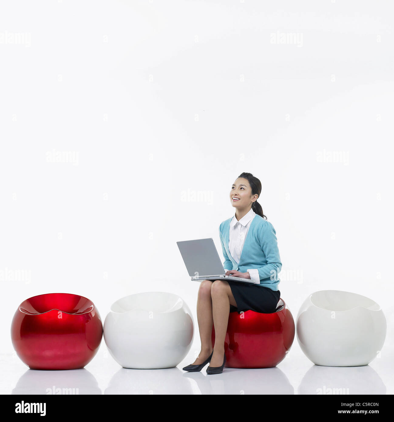 A woman sitting on a chair doing notebook computer Stock Photo - Alamy