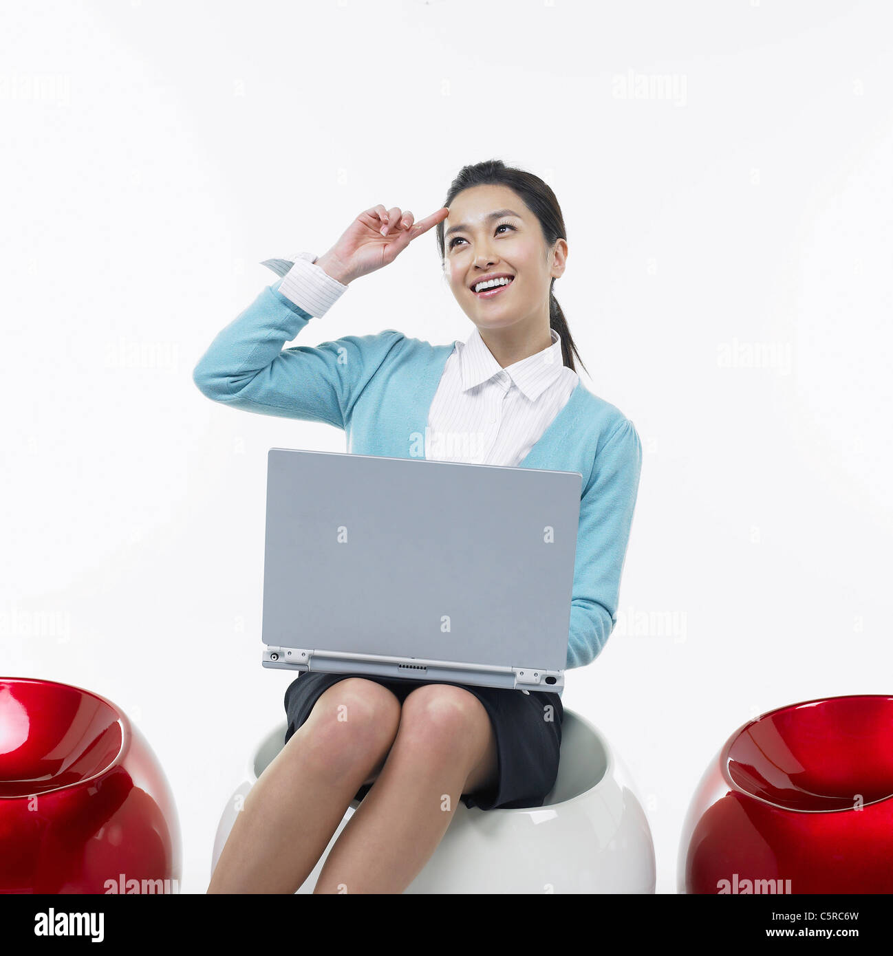 A woman sitting on a chair doing notebook computer Stock Photo - Alamy