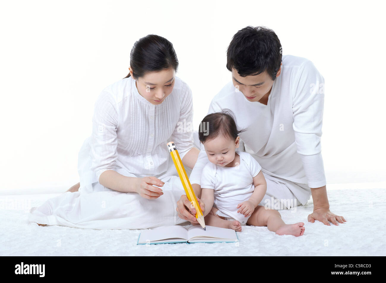 A baby studying with the parents Stock Photo - Alamy