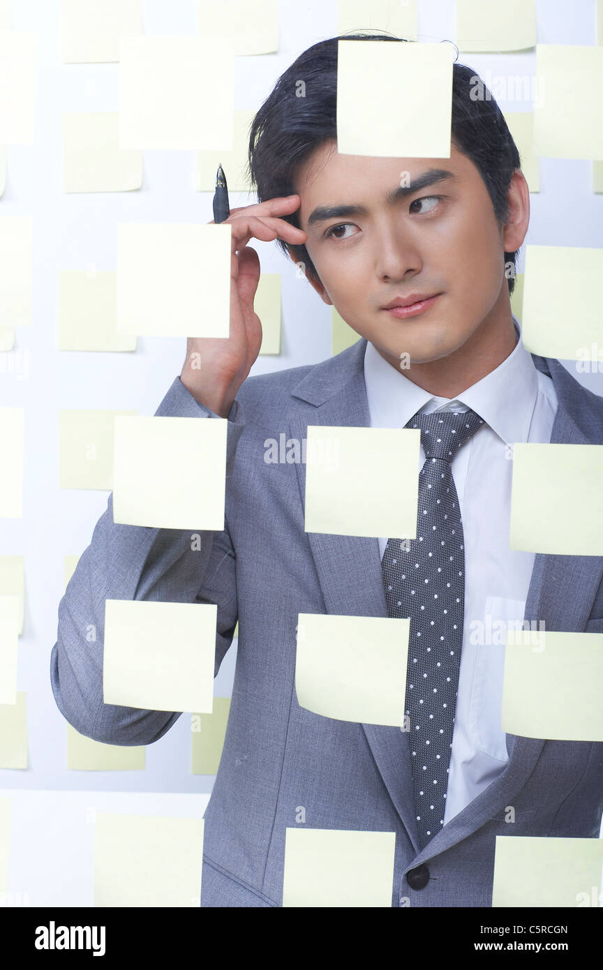 A business man smiling in front of post its Stock Photo - Alamy