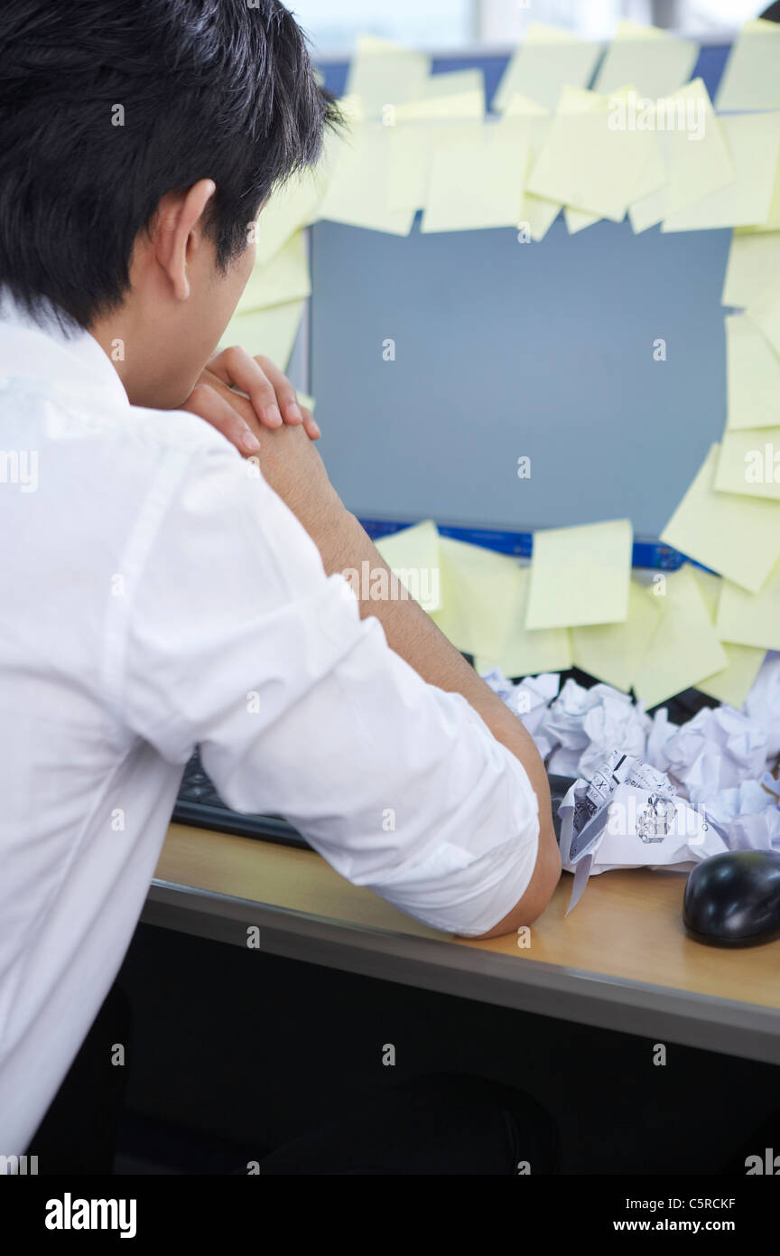 A business man thinking in front of disordered desk Stock Photo - Alamy