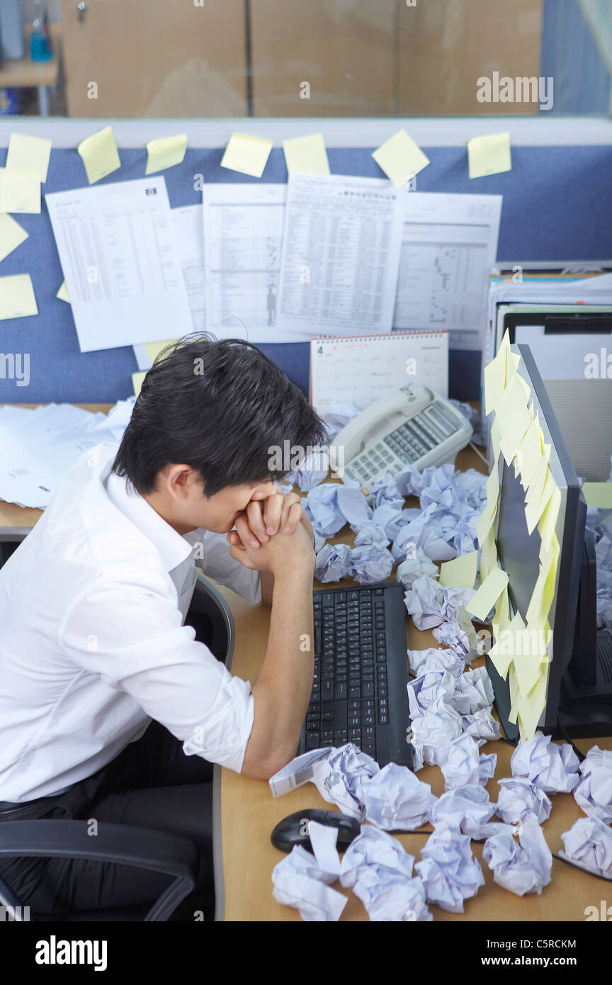 A business man in agony in front of disordered desk Stock Photo - Alamy