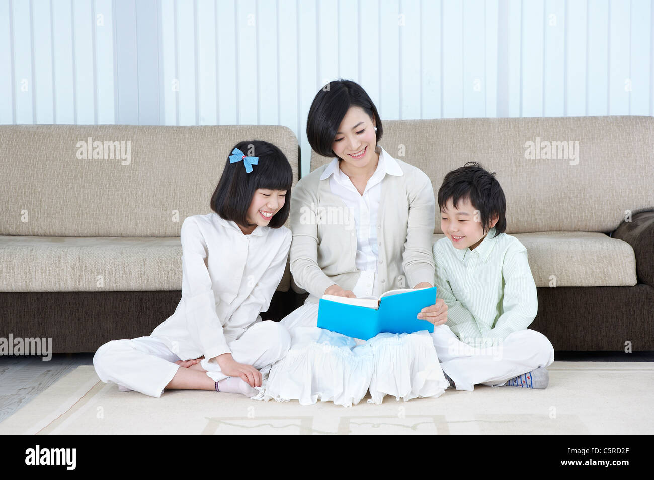 A family reading a book together Stock Photo - Alamy