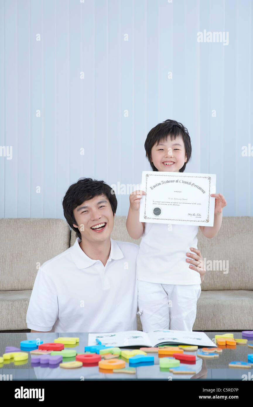 A boy holding a certificate and his father being proud of him Stock ...