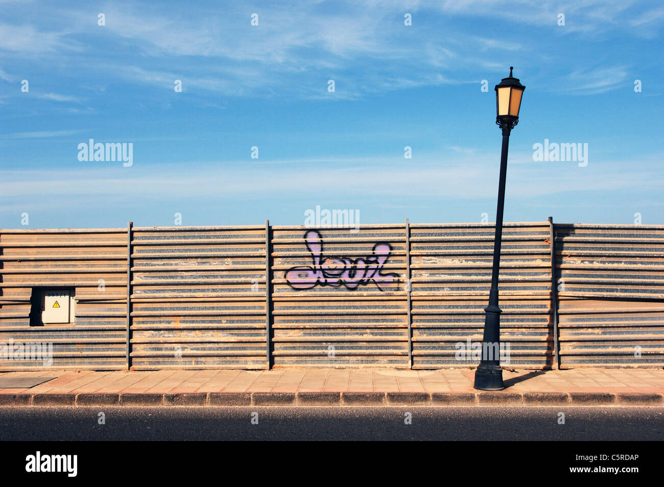 Leaning street lamp, graffiti on wall Stock Photo - Alamy