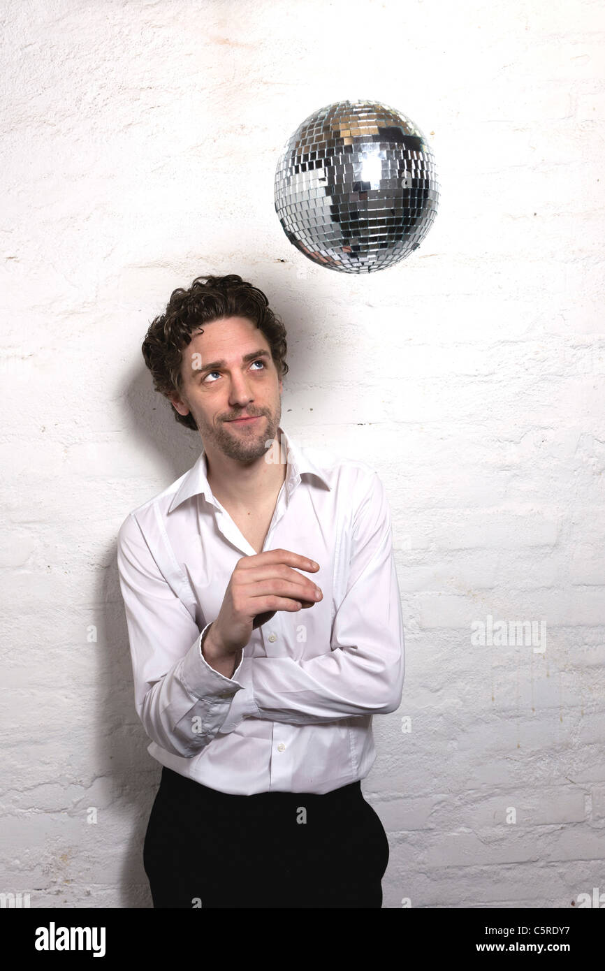 Mid adult man looking at disco ball Stock Photo - Alamy
