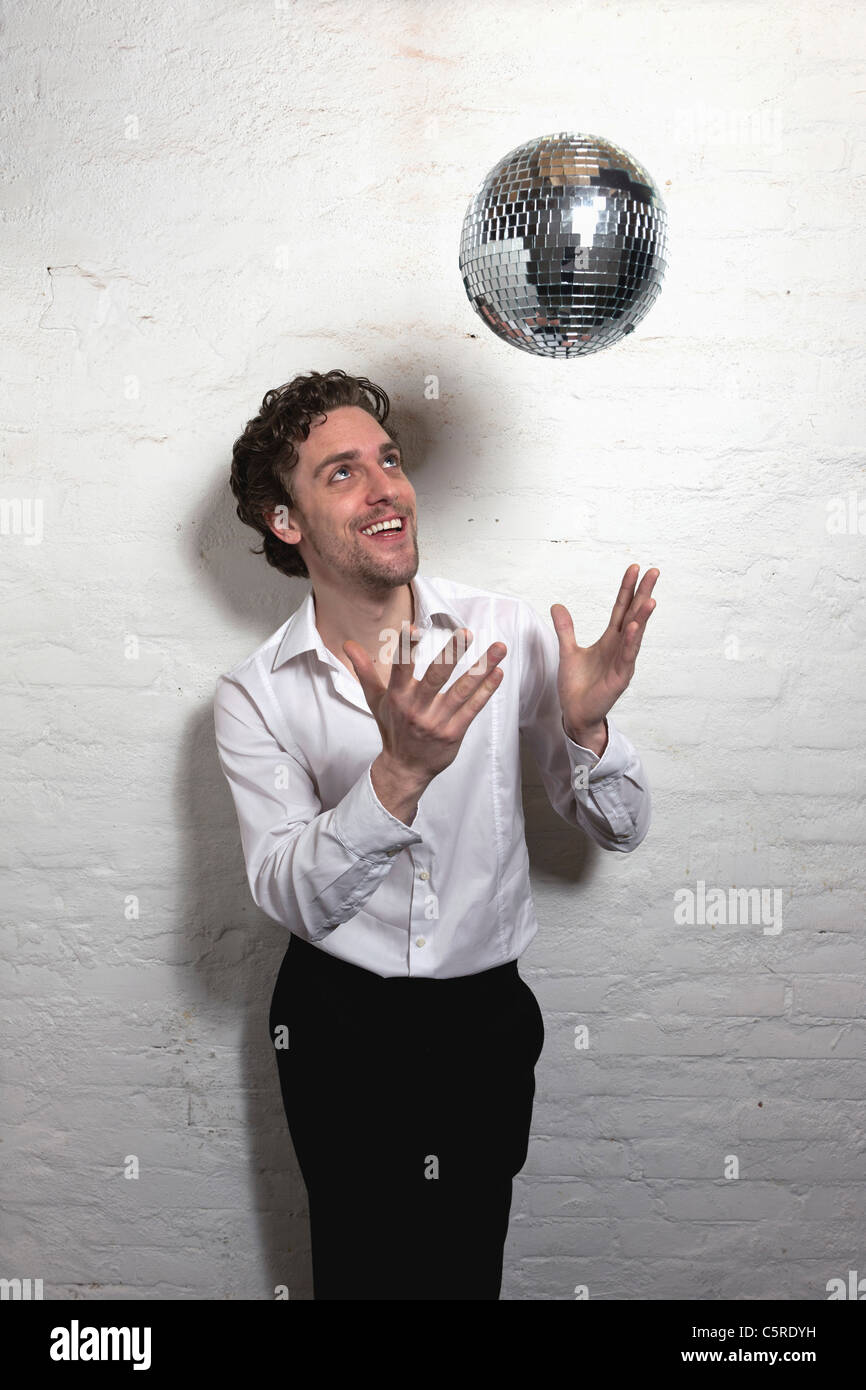 Mid adult man looking at disco ball Stock Photo - Alamy