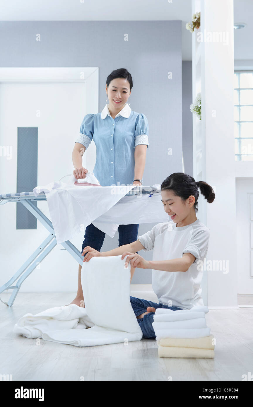 A mother ironing and her daughter folding laundry Stock Photo - Alamy