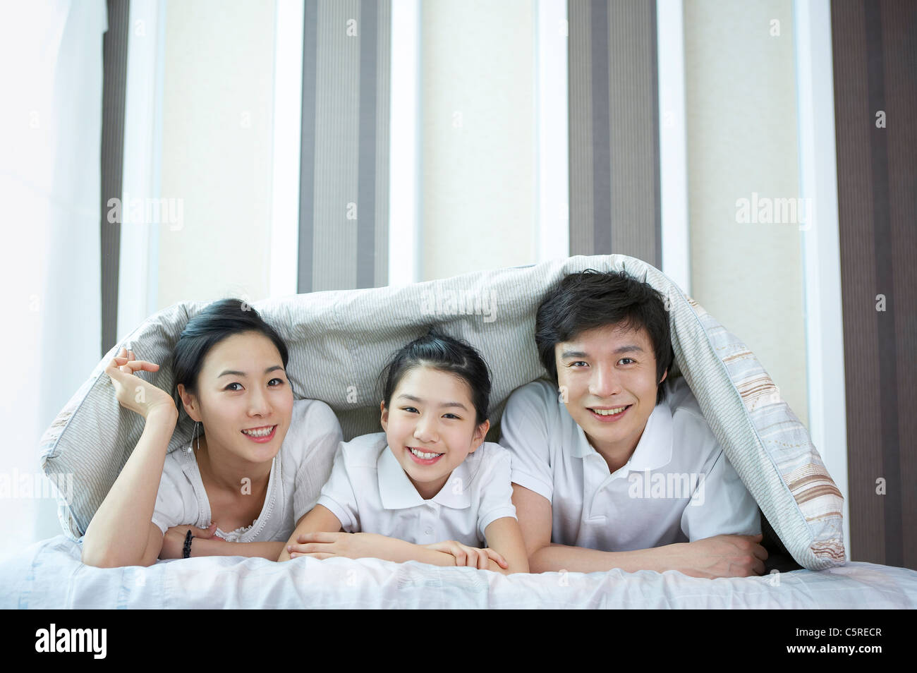 A family inside a blanket Stock Photo - Alamy