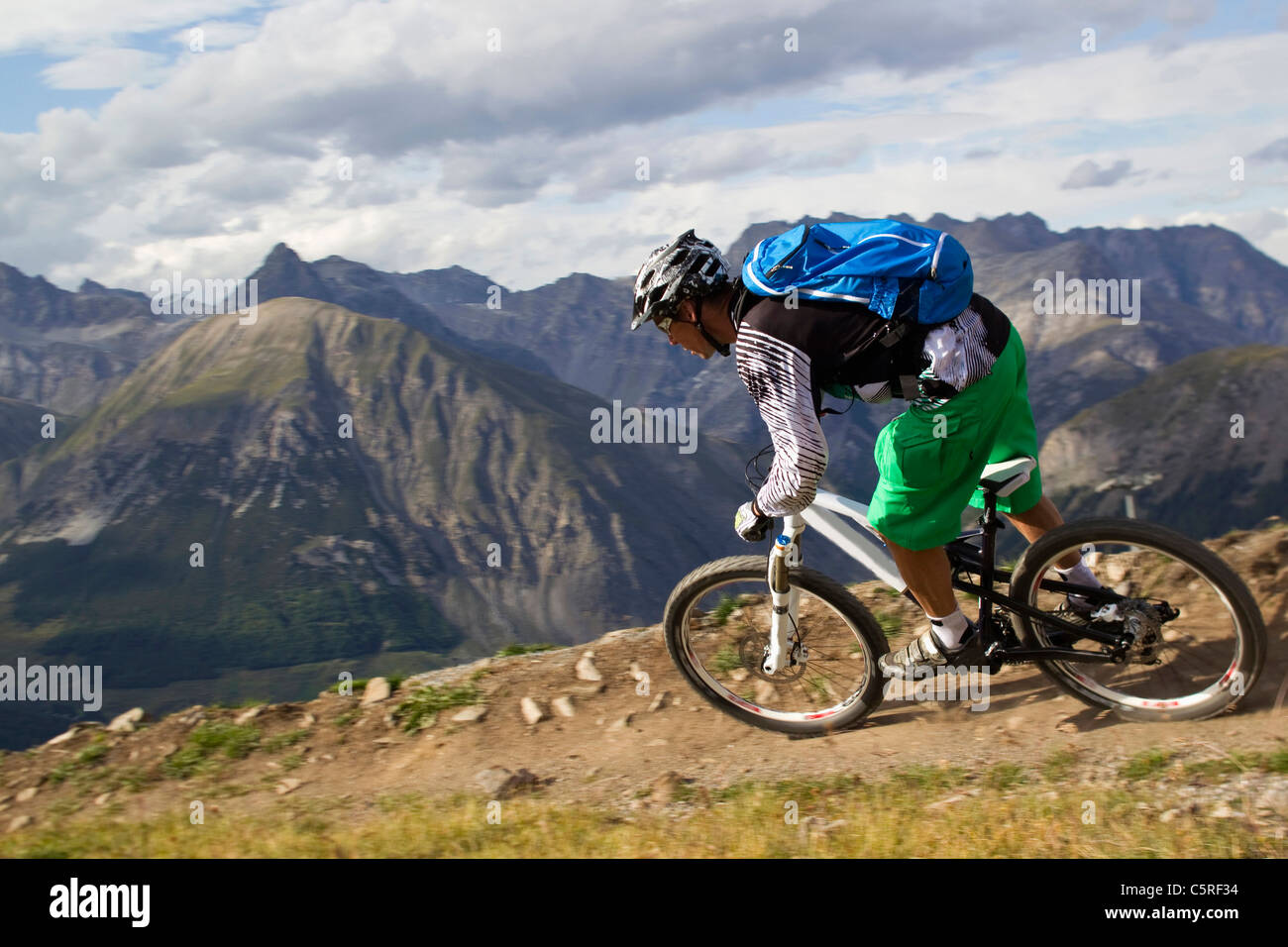Italy, Livigno, View of man riding mountain bike downhill Stock Photo ...