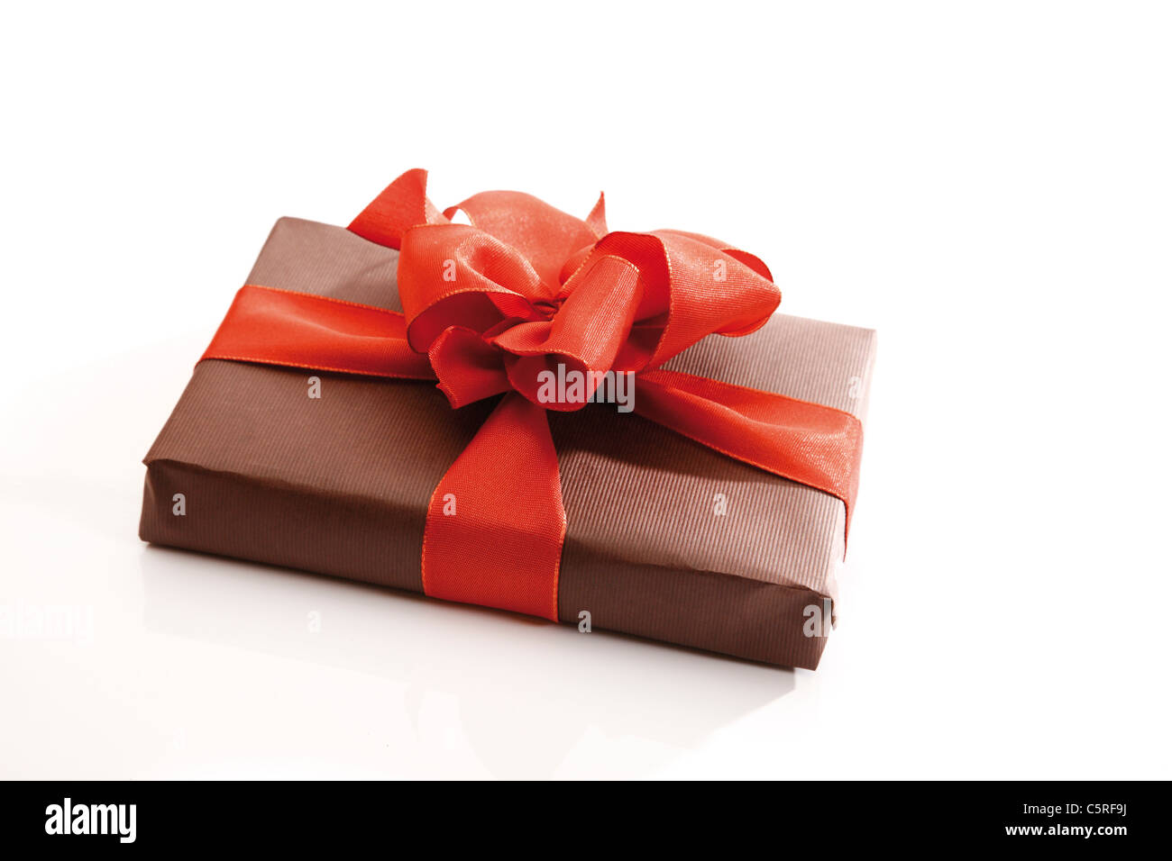 Gift parcel with red ribbon Stock Photo - Alamy