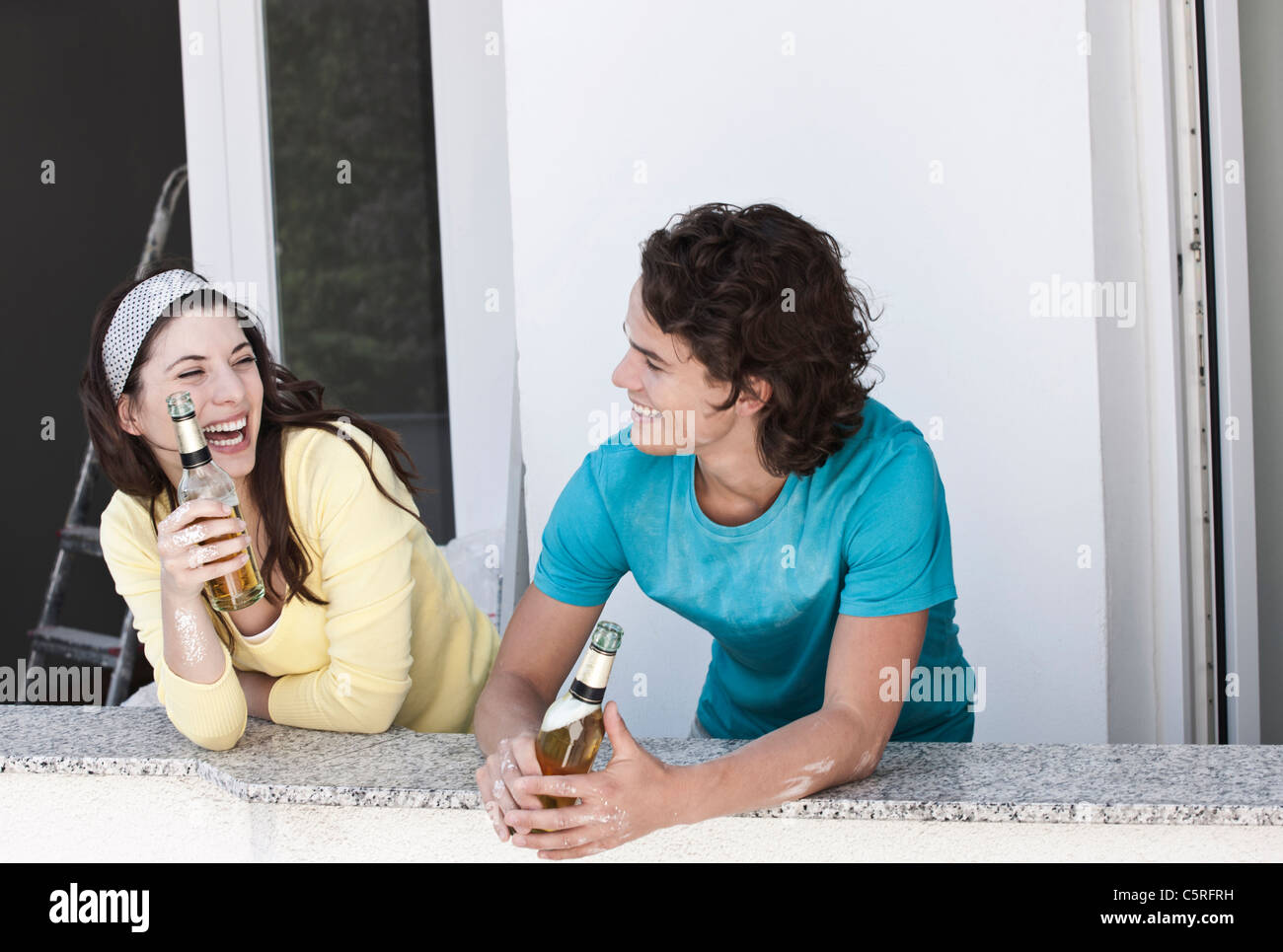Germany, Cologne, Young couple drinking beer in apartment Stock Photo ...