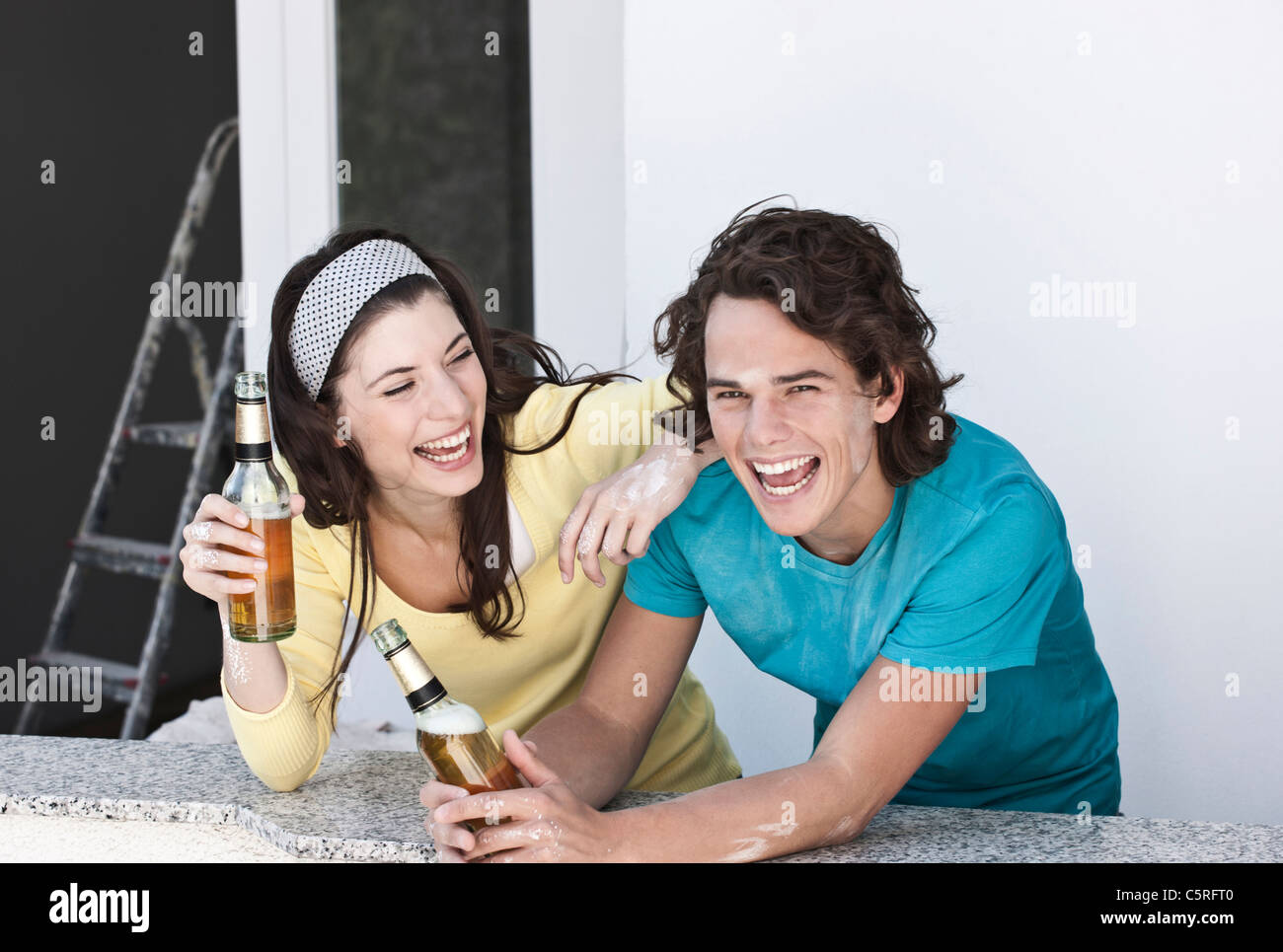 Germany, Cologne, Young couple drinking beer in apartment Stock Photo ...