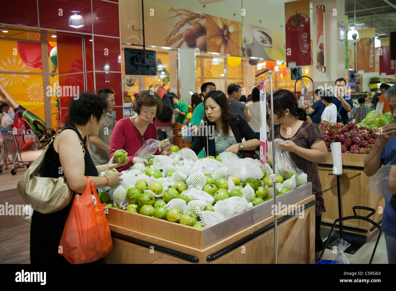 Shoppers pick over the guava on sale at the new Sky Foods supermarket ...