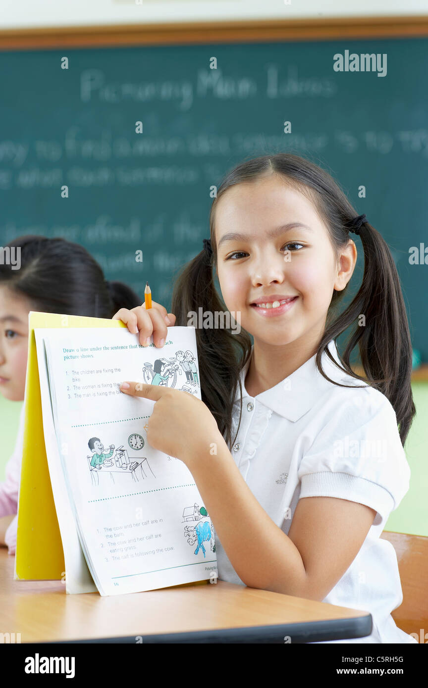 An asian girl pointing at a book Stock Photo - Alamy