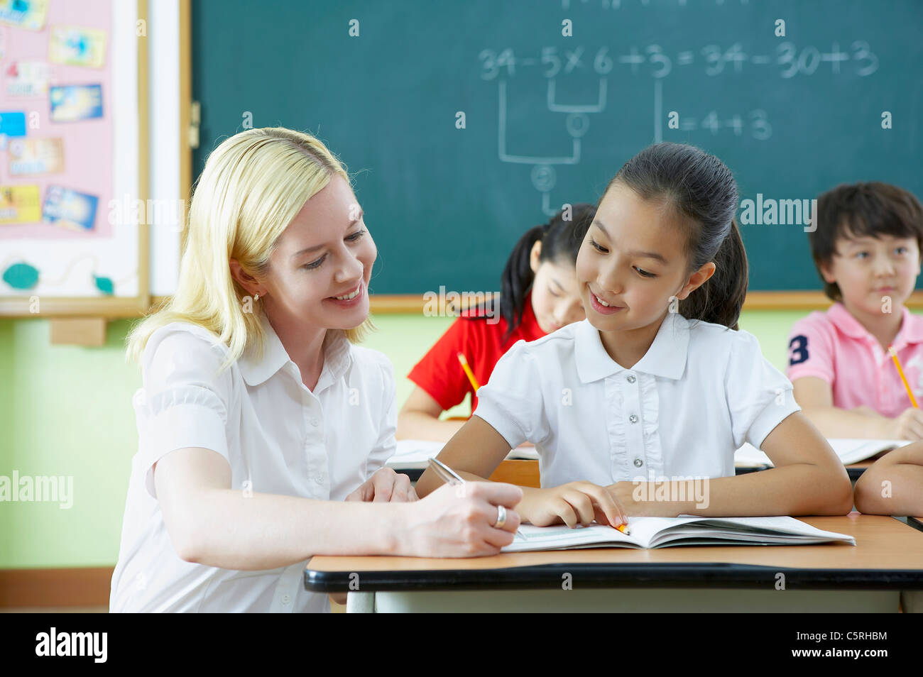 A teacher helping students Stock Photo - Alamy