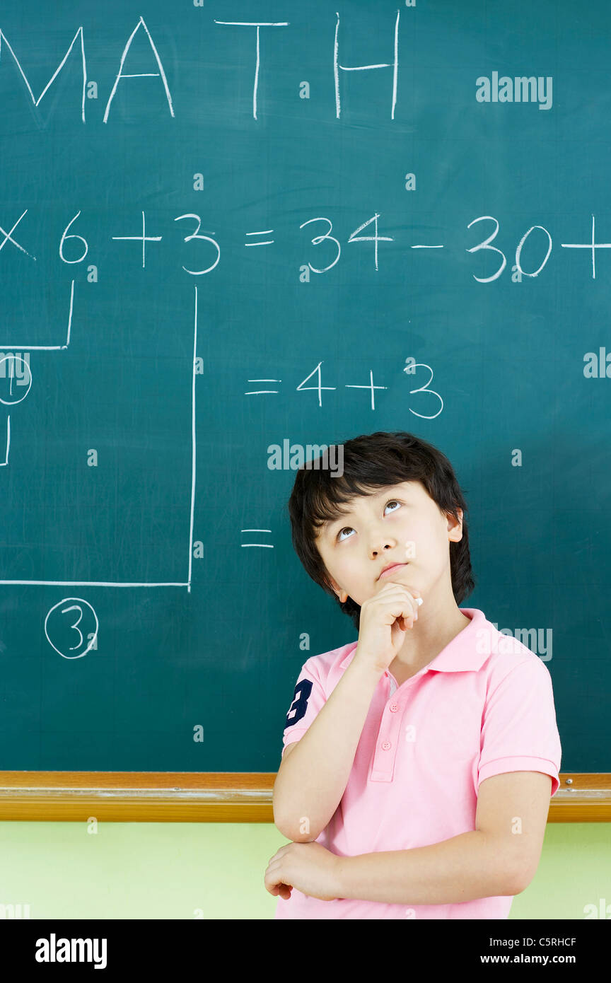 A student thinking in front of a blackboard Stock Photo - Alamy