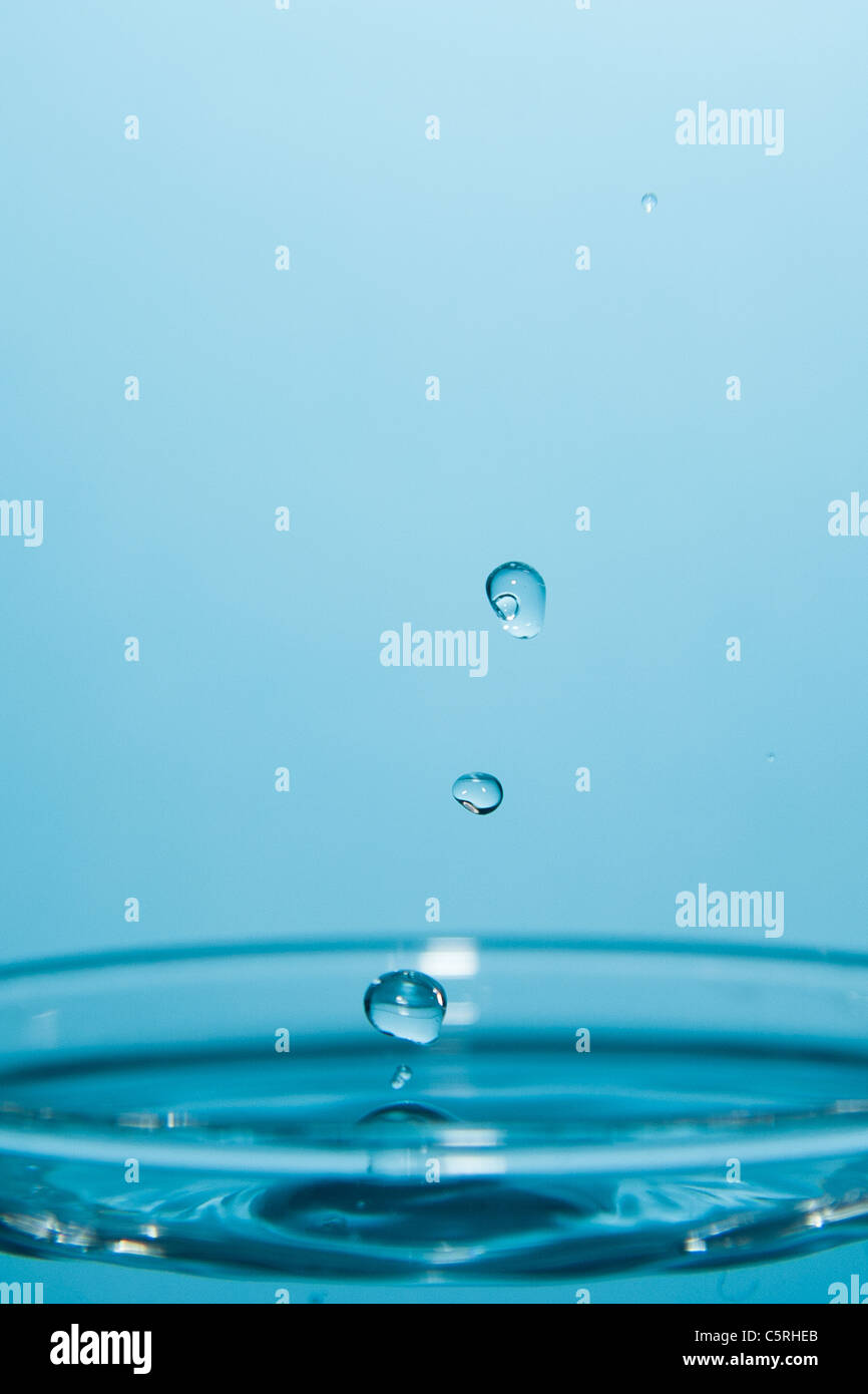 Drops of blue water hitting the surface Stock Photo - Alamy