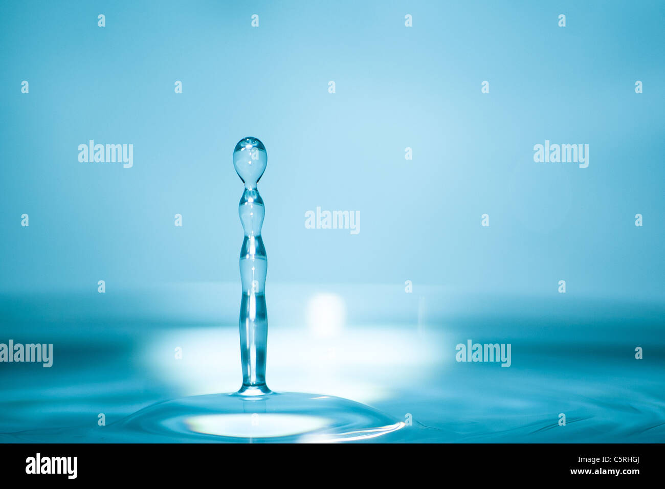 A perfectly-frozen splash of water against a blue background Stock ...