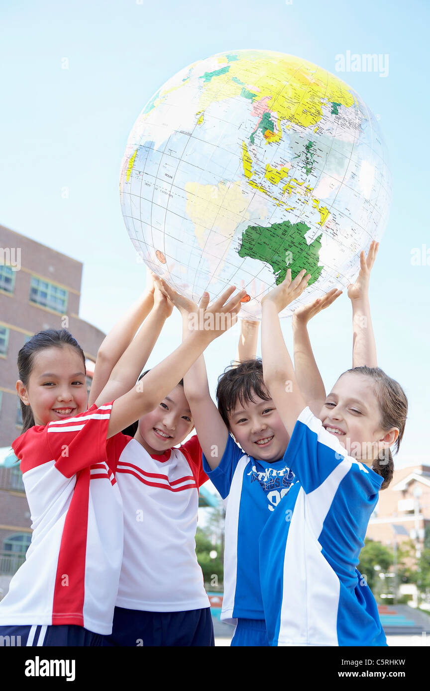 Students holding a globe together Stock Photo - Alamy
