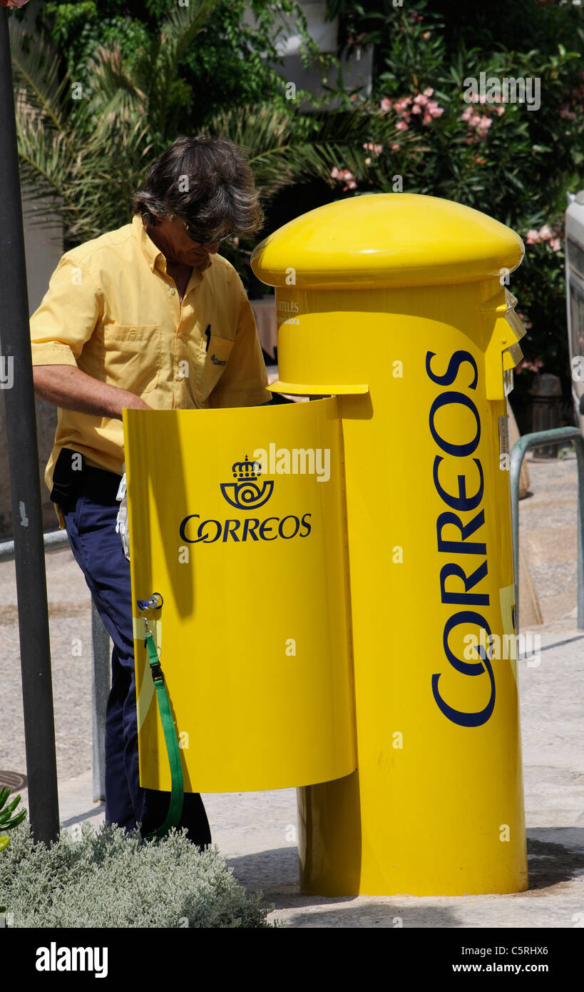 Spanish postman emptying a yellow letter box Stock Photo - Alamy