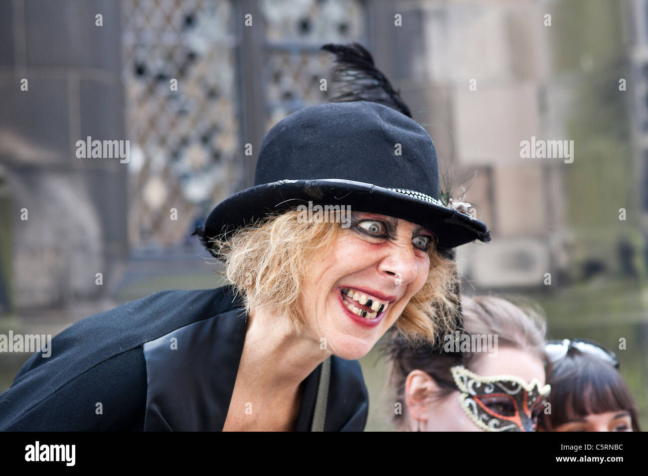 A female performer with blackened teeth poses on Edinburgh's Royal Mile ...
