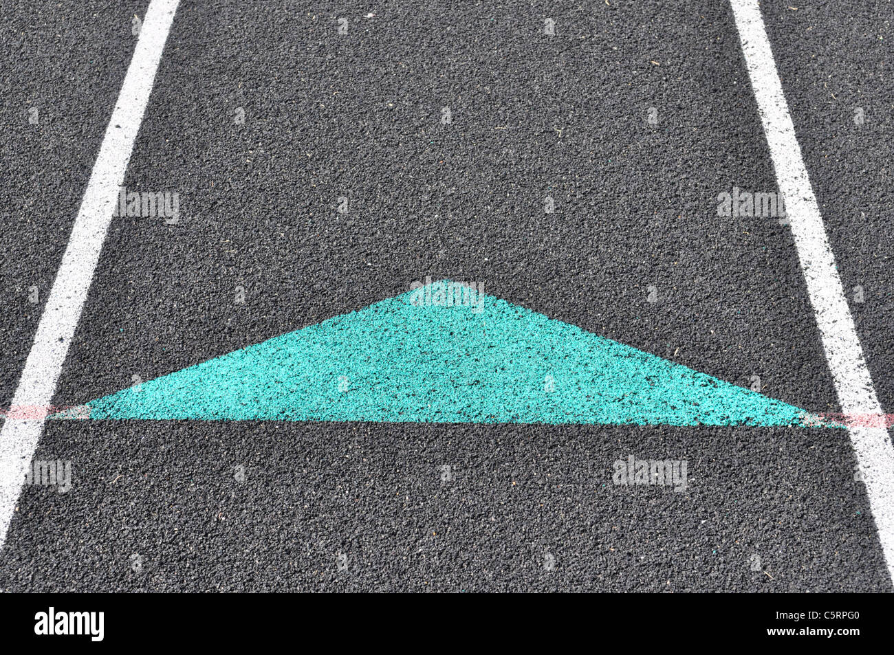 A blue triangle marking is on a black top running track Stock Photo - Alamy