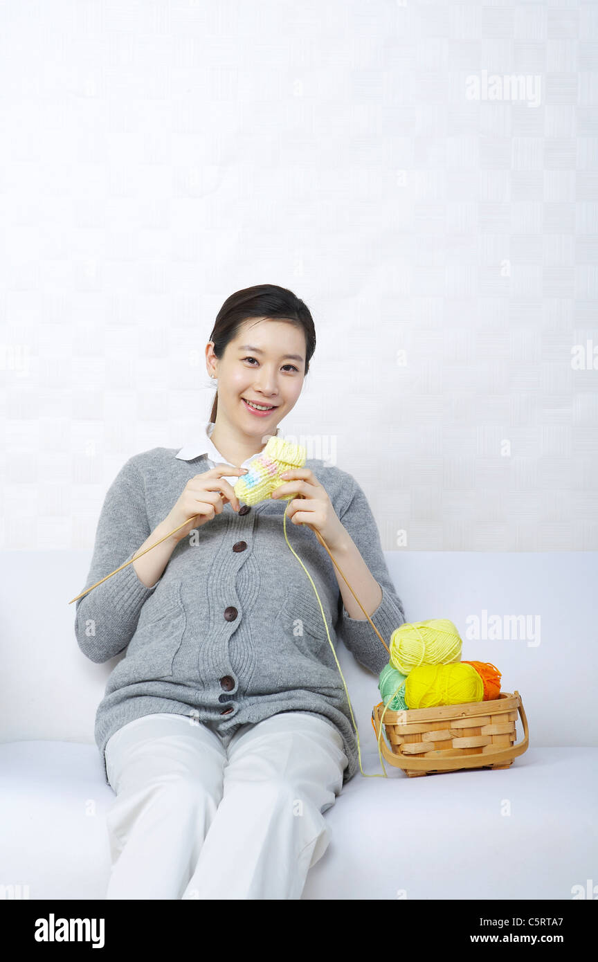 A pregnant woman knitting baby's socks Stock Photo - Alamy