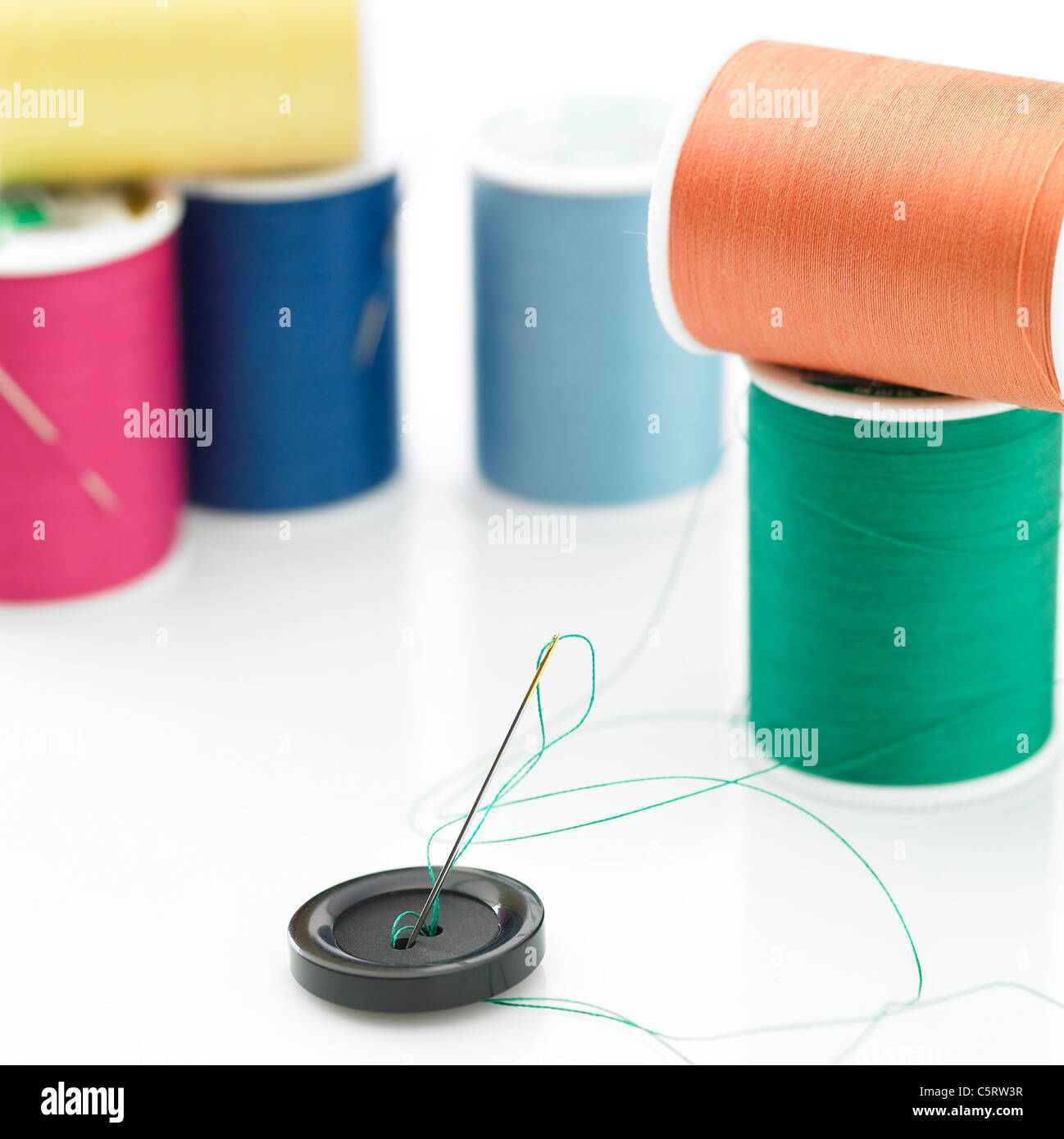 Thread, needle and a button Stock Photo - Alamy
