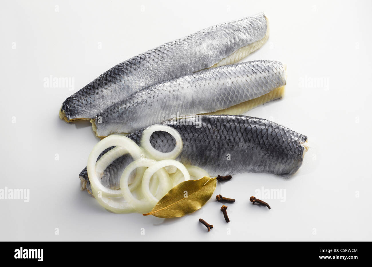 Close up of ingredients used for pickled herring against white ...