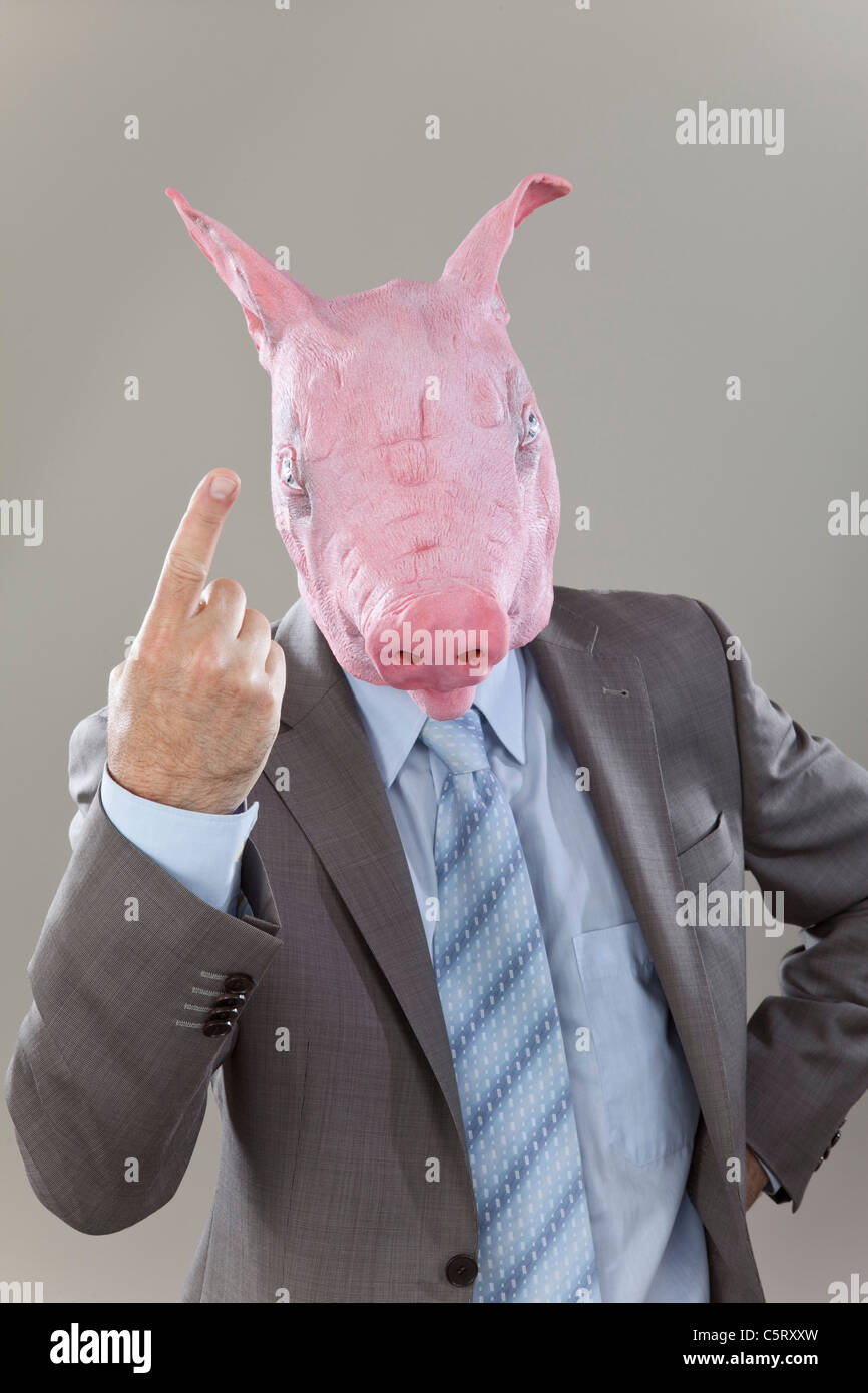 Close up of businessman with pigs head in office against grey ...