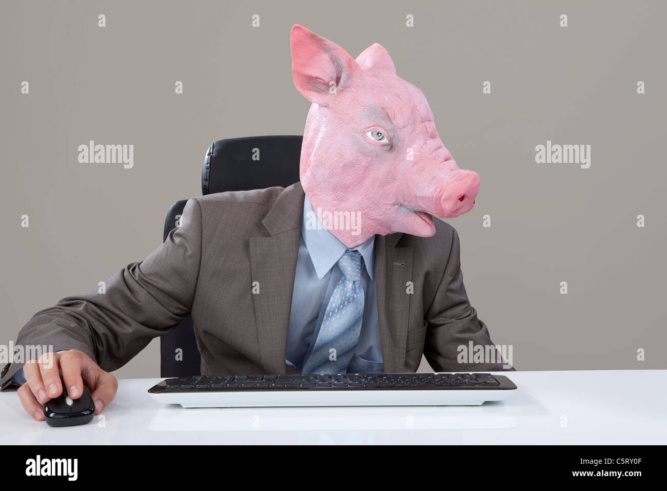 Close up of businessman with pigs head using computer in office against ...