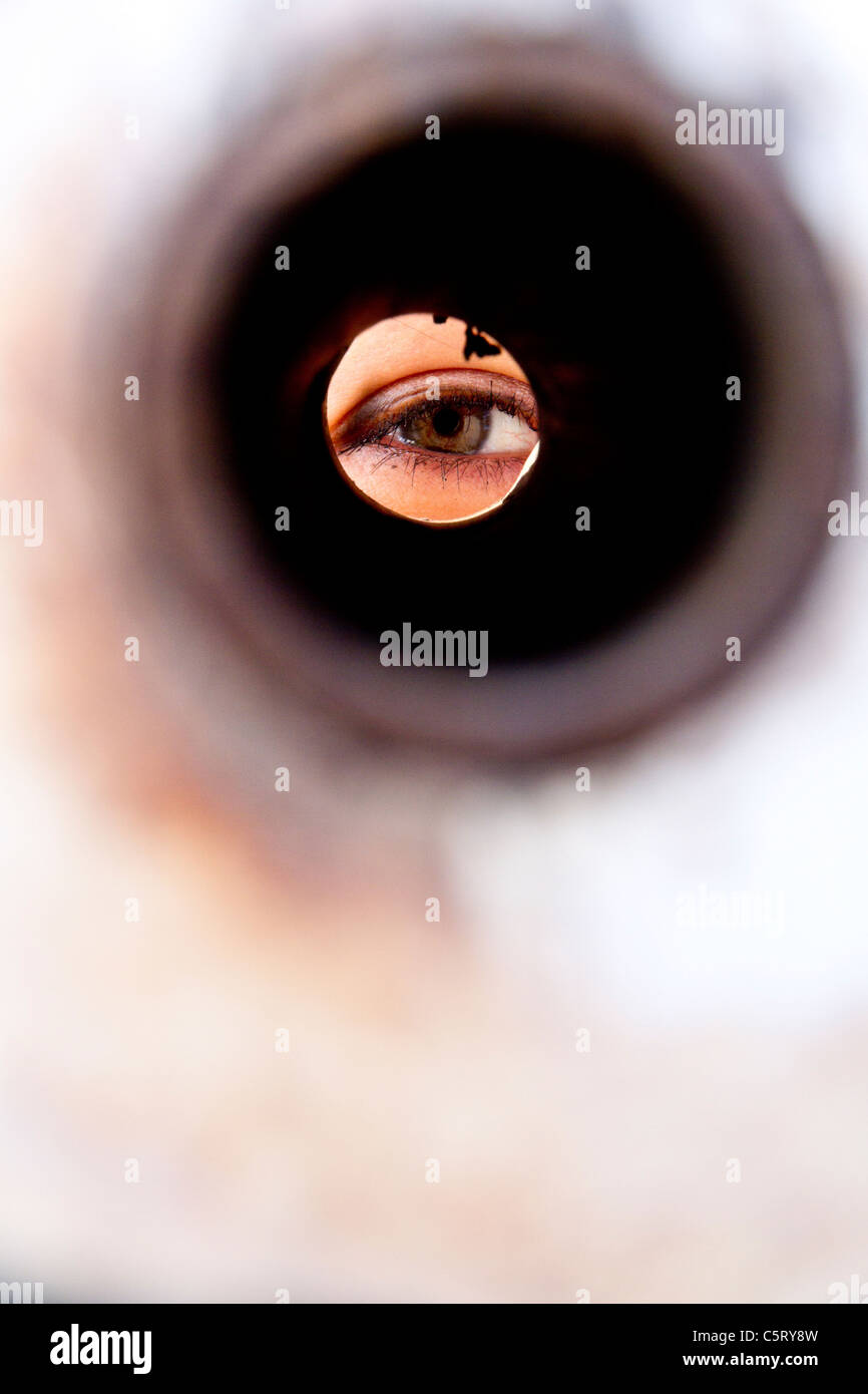 Close up of woman's eye looking through tube Stock Photo - Alamy
