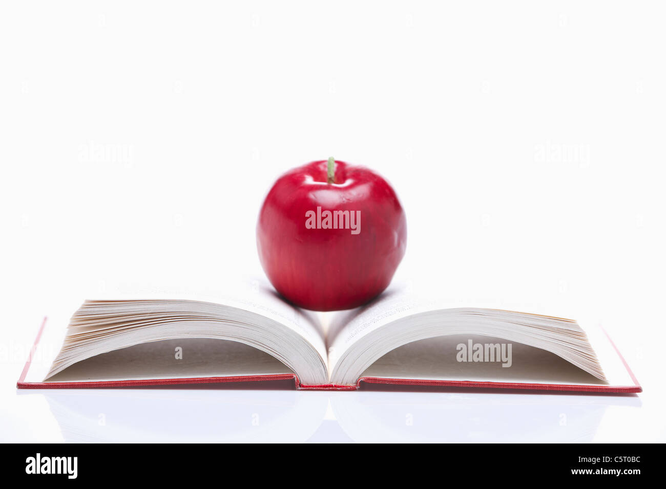 apple on the opened book Stock Photo - Alamy