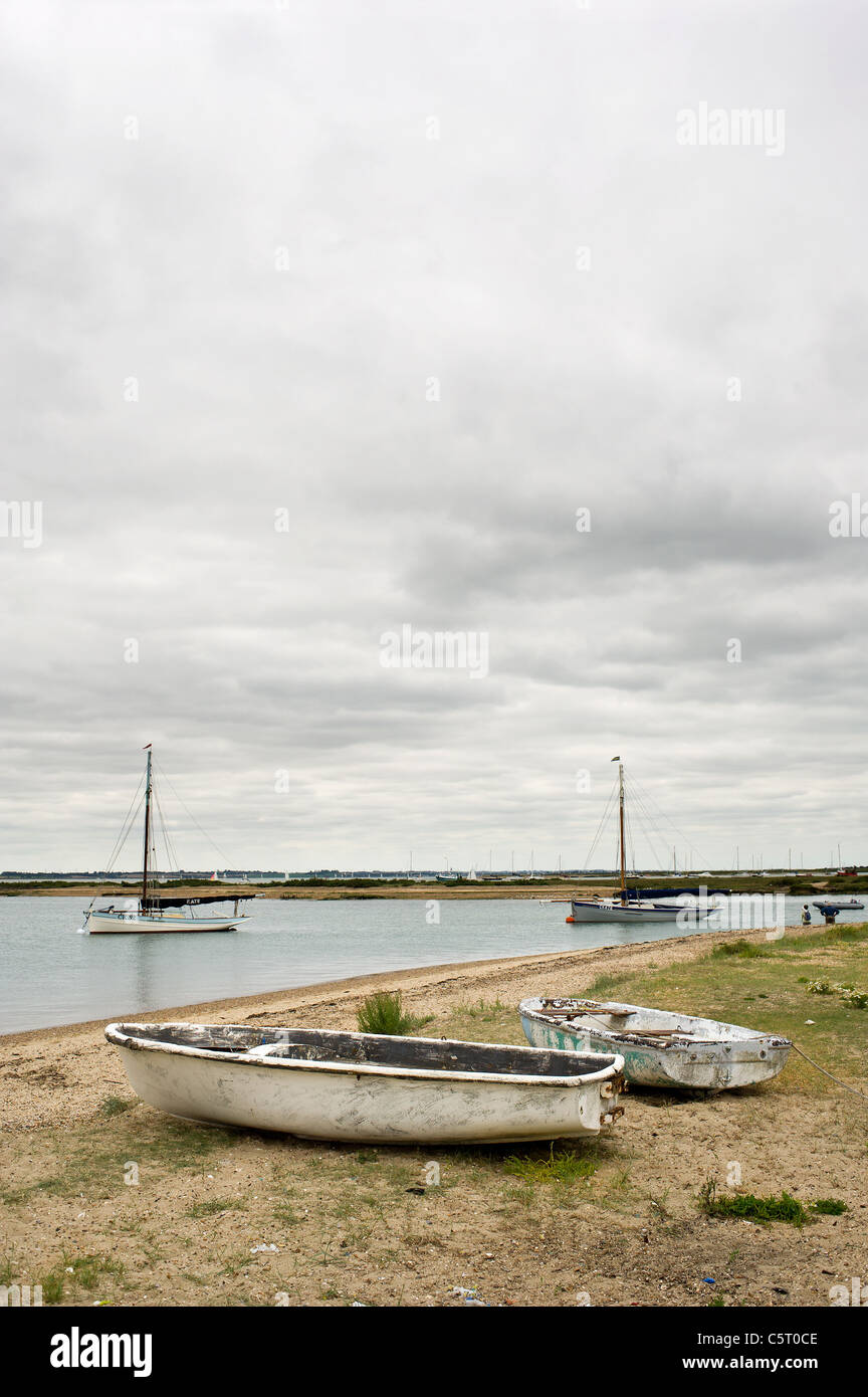Old rowing boats beached on the foreshore of Mersea Island in Essex ...