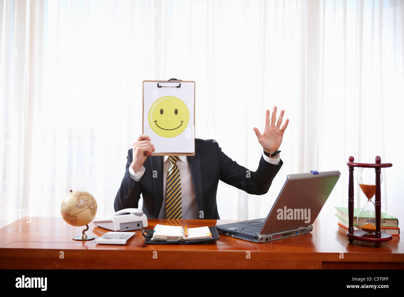 man holding paper which has smile face Stock Photo - Alamy