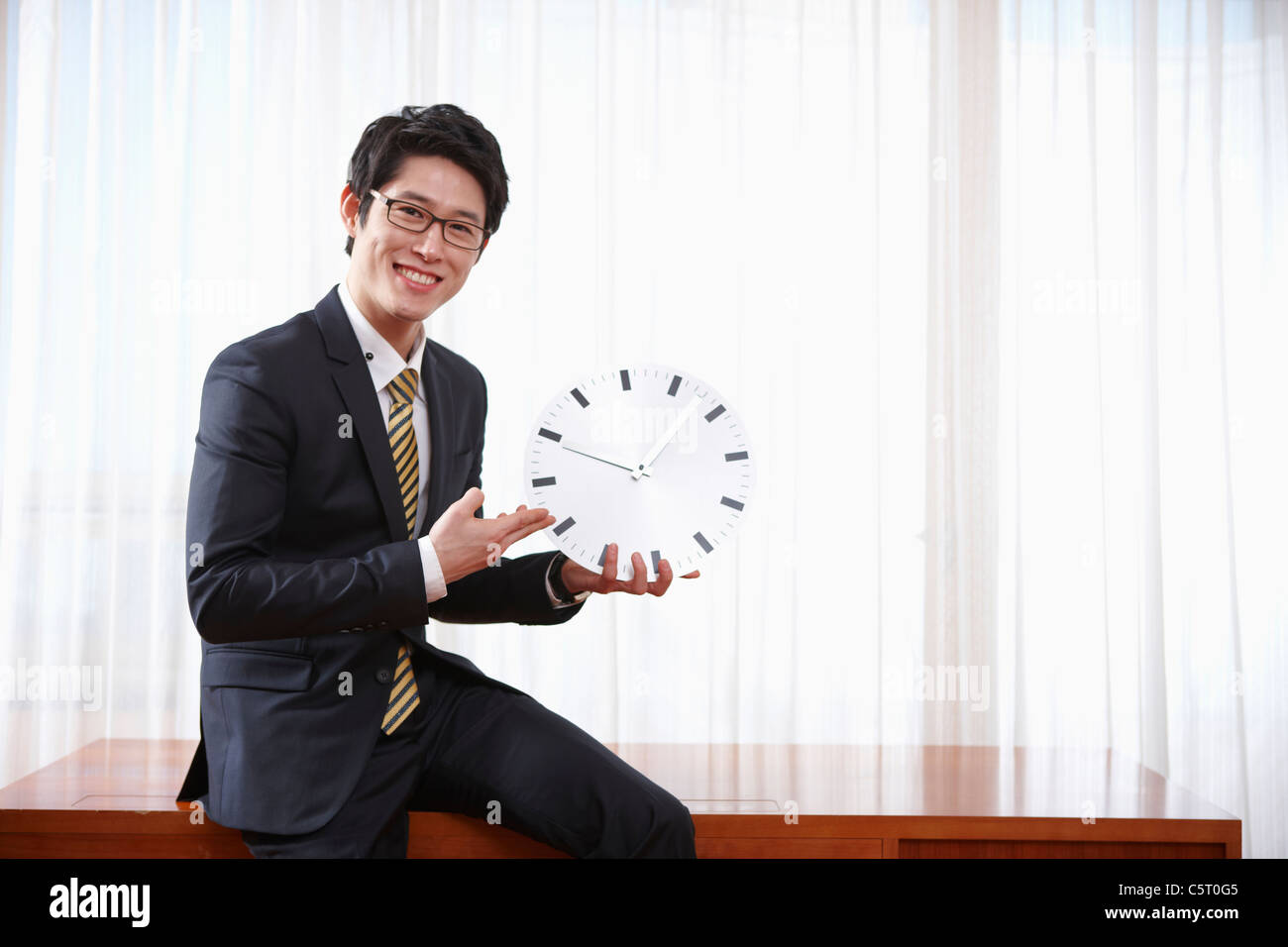 man holding clock Stock Photo - Alamy