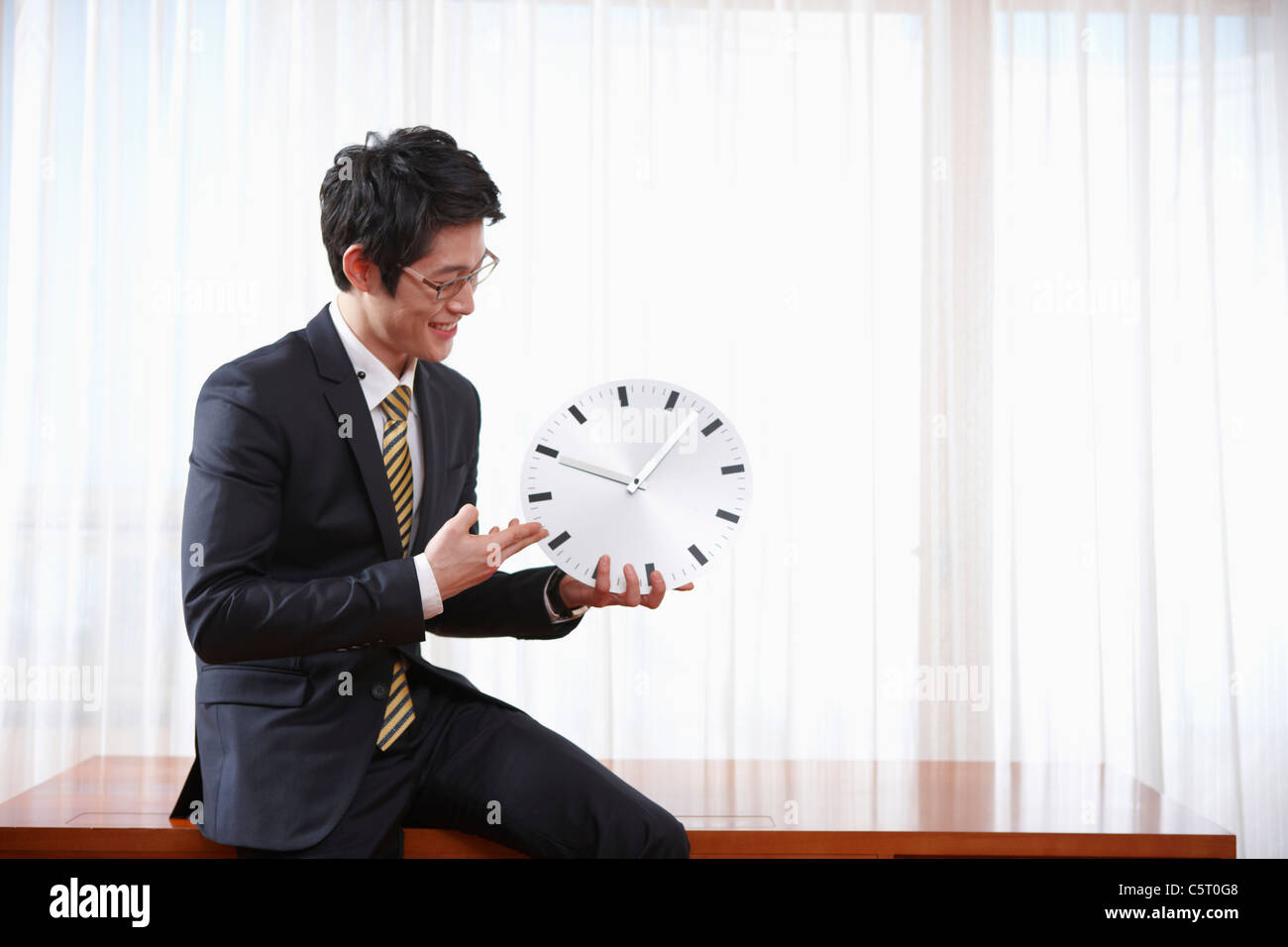 man holding clock Stock Photo - Alamy