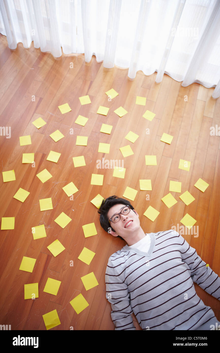 man stretched his arms out lying on the floor Stock Photo - Alamy