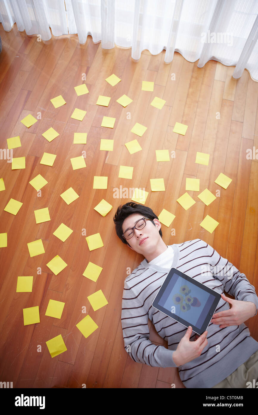 man holding tablet pc lying on the floor Stock Photo - Alamy