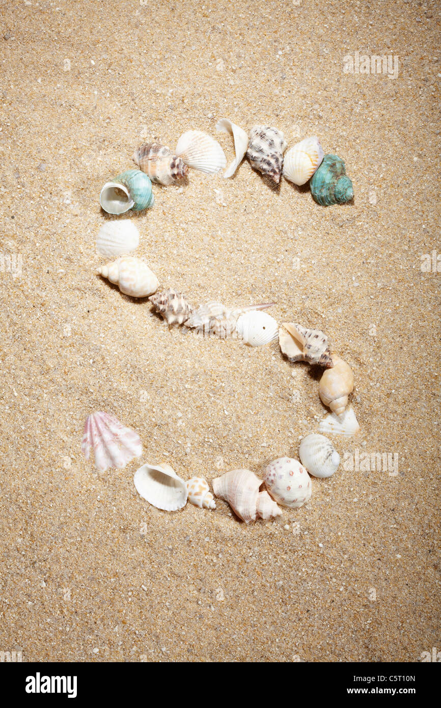 sea shells make letter of S on the sand Stock Photo - Alamy