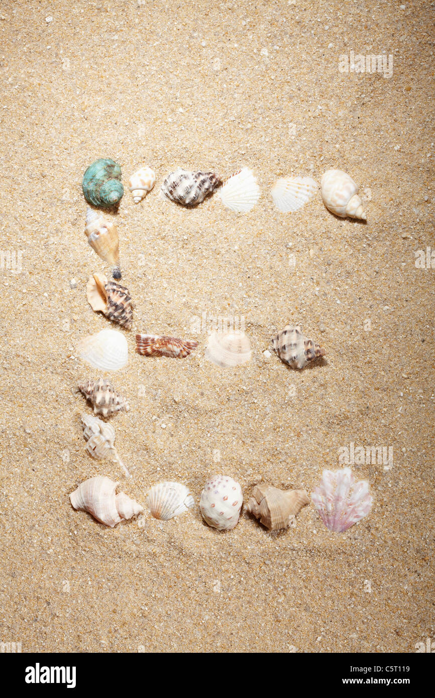 sea shells make letter of E on the sand Stock Photo - Alamy