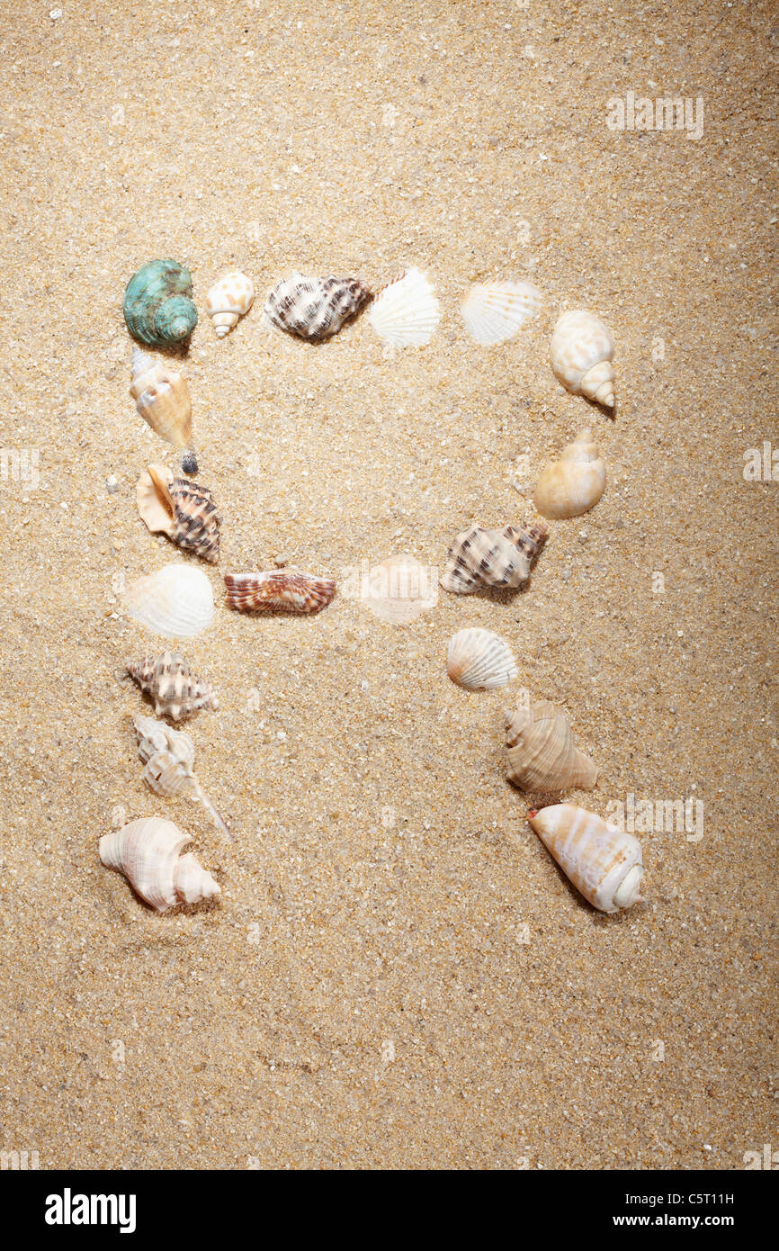 sea shells make letter of R on the sand Stock Photo - Alamy