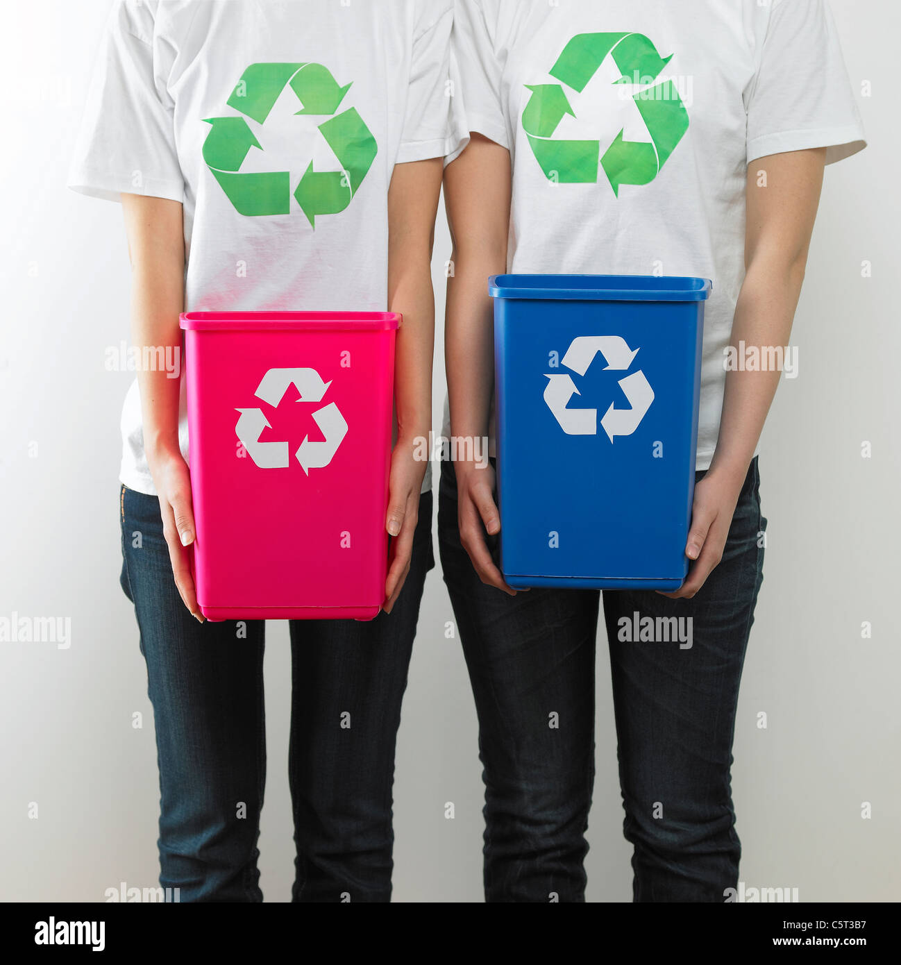 Two people holding recycling bin Stock Photo - Alamy