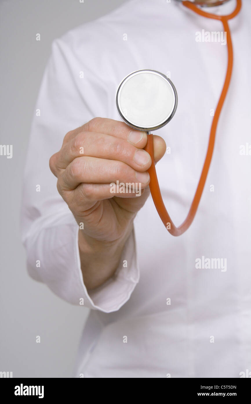 Close up of doctor holding stethoscope against grey background Stock ...